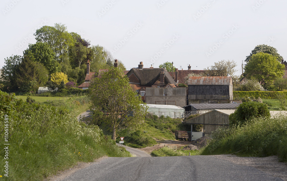 Typical English Farm. A country road curves and dips past a typical old ...