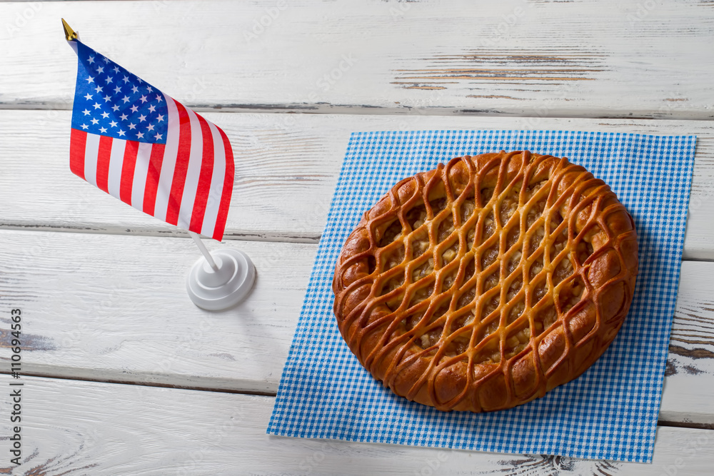 American flag beside round pie. Pie, napkin and small flag. Traditional ...