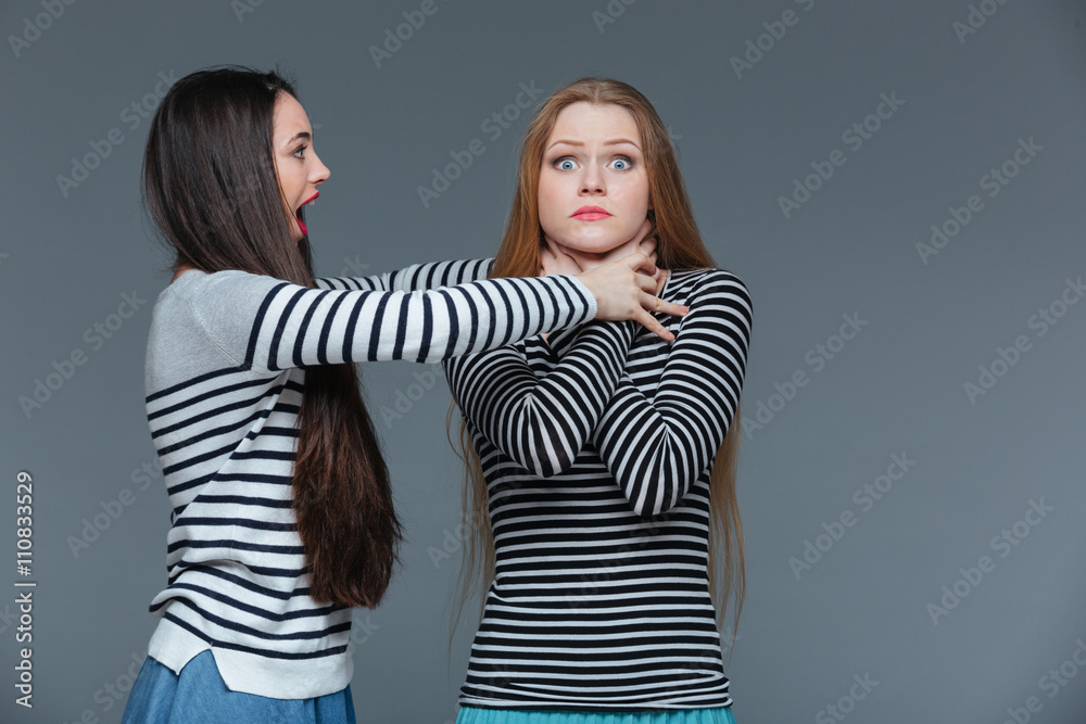 Mad angry woman standing and strangling shocked young female Stock ...