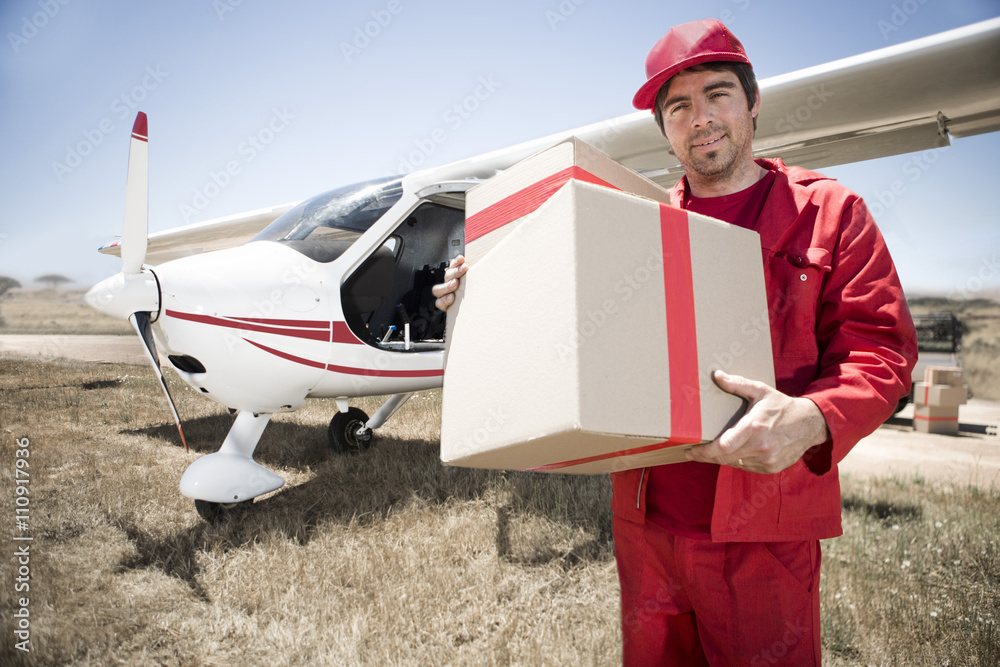 Delivery man carrying parcel off airplane, Wellington, Western Cape ...