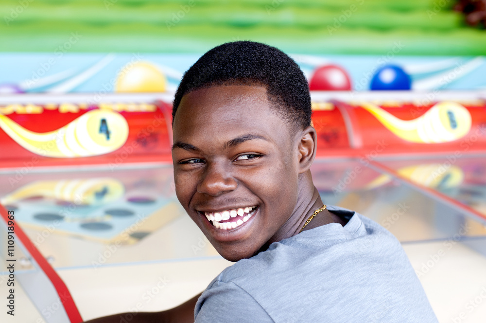 Teenage boy looking over his shoulder at amusement park Stock Photo ...