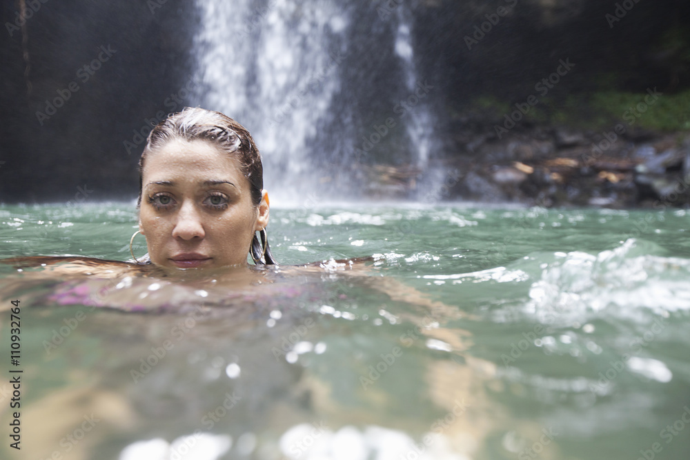Woman swimming, waterfall in background Stock Photo | Adobe Stock