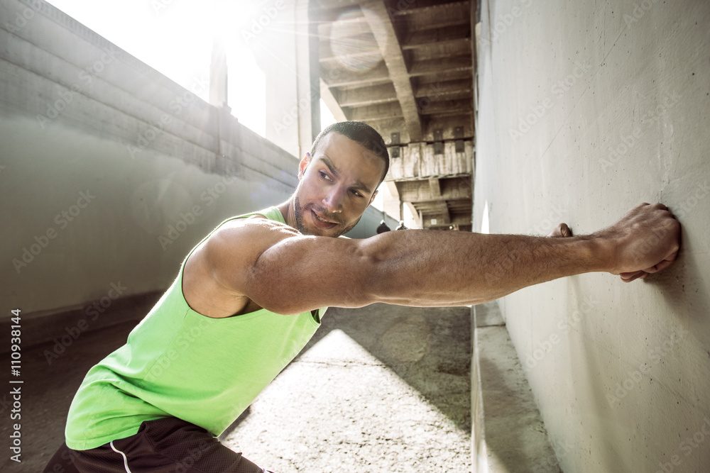 Muscular male runner doing wall push ups under city bridge Stock Photo ...