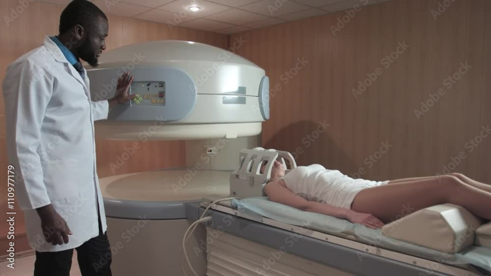 Head mri scanning prodedure. Male african american assistant spends ...