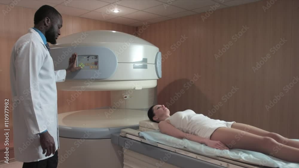 Radiologist move down mri patient table with female patient in the ...