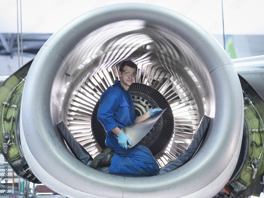 Engineer holding jet engine turbine blade in aircraft maintenance ...