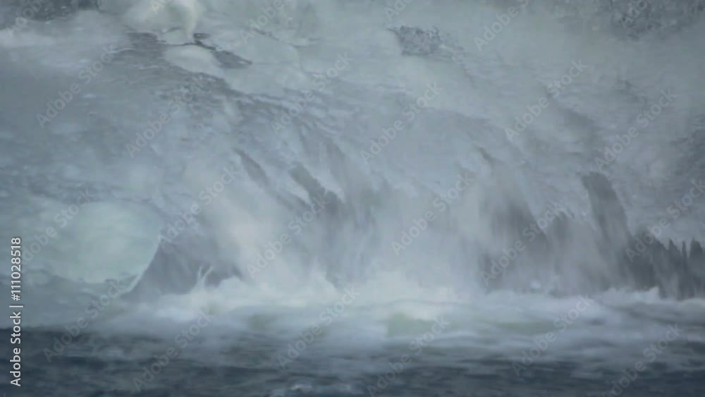 Falling water in winter. Flowing water under ice crystals. Closeup ...