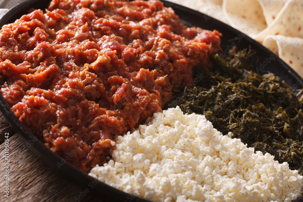 Ethiopian kitfo with herbs and cheese ayibe close-up. horizontal ...