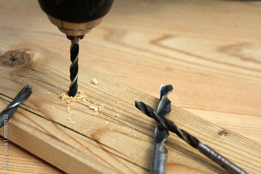 Detail of drill bit in a wooden plank. Wooden board as a background ...