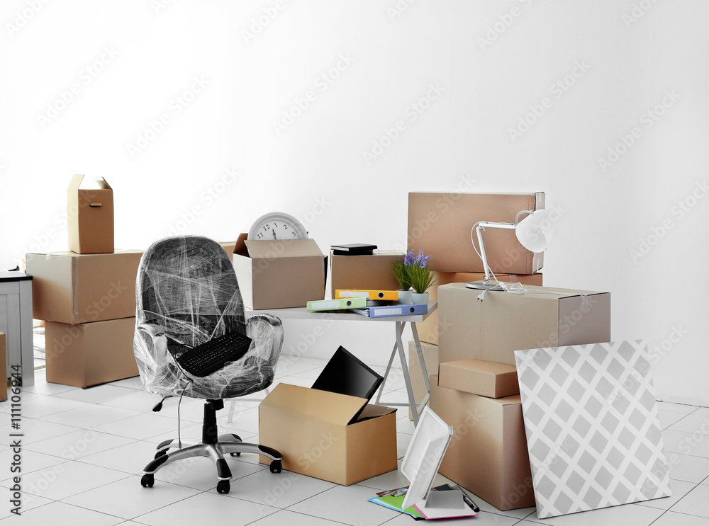 Moving cardboard boxes and personal belongings in empty office space ...