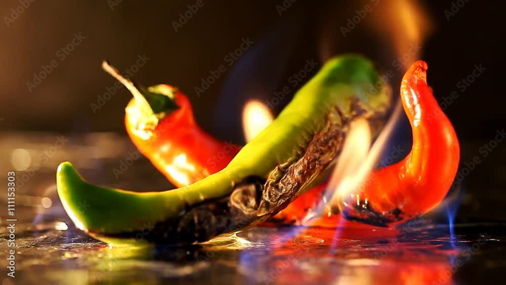 hot pepper in fire arms / hot pepper in flames on a black background ...