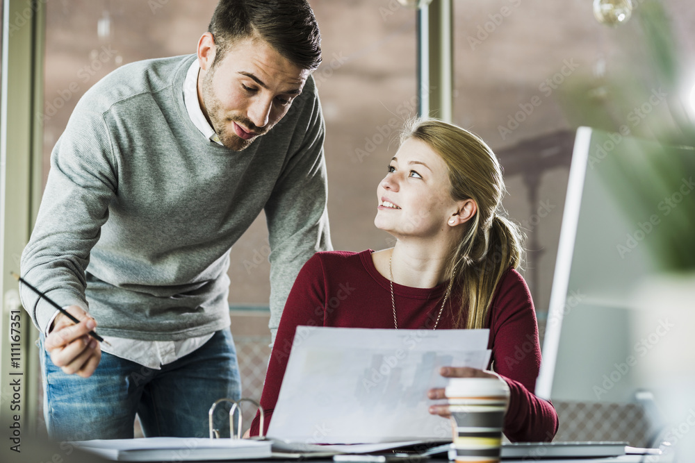 Two colleagues discussing paper at office desk Stock-Foto | Adobe Stock