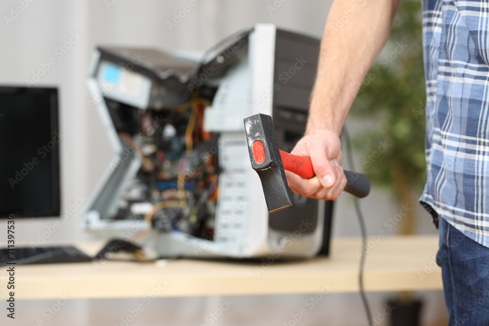 Hand holding a hammer after destroy a computer Stock Photo | Adobe Stock