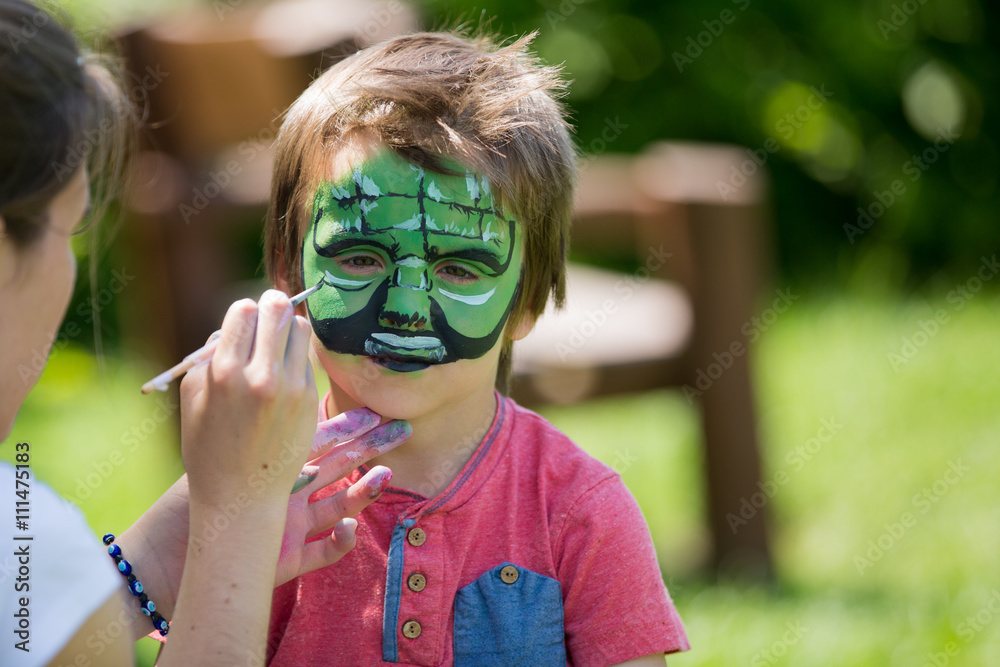 Cute little five years old boy,. having his face painted on his Stock ...
