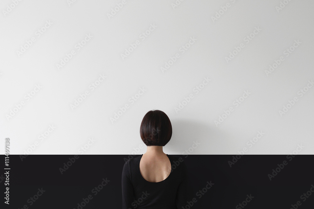 Rear view of woman standing facing wall Stock Photo | Adobe Stock