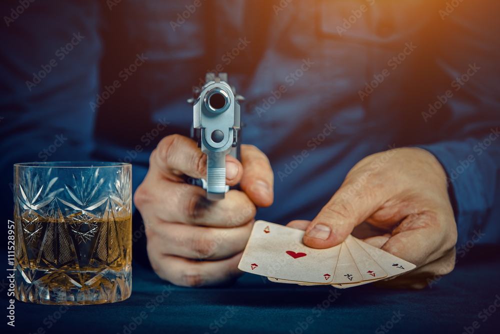 lucky gangster pointing gun at camera and showing four aces card Stock ...