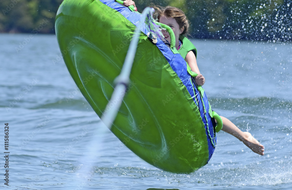 Young teenage girl doing a trick on a float behind a boat. Stock Photo ...