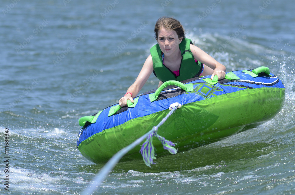 Young teenage girl doing a trick on a float behind a boat. Stock Photo ...