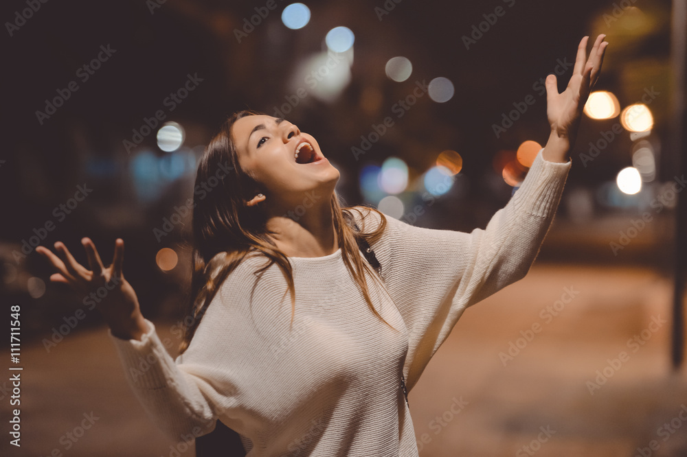 Young emotional stressed woman screaming looking up, city street in the ...