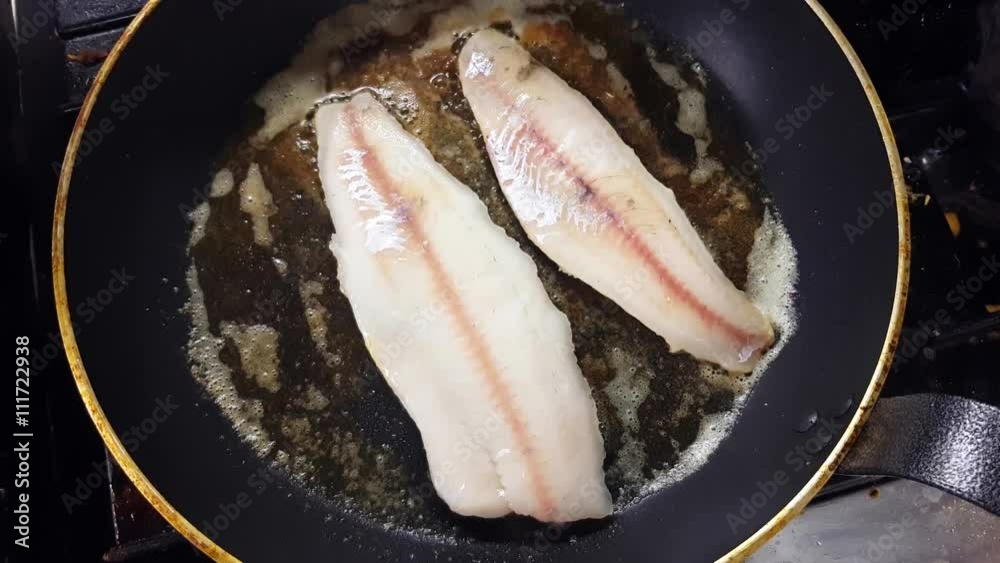 Frying white zander fillets, on a frying pan, inside a restaurant ...
