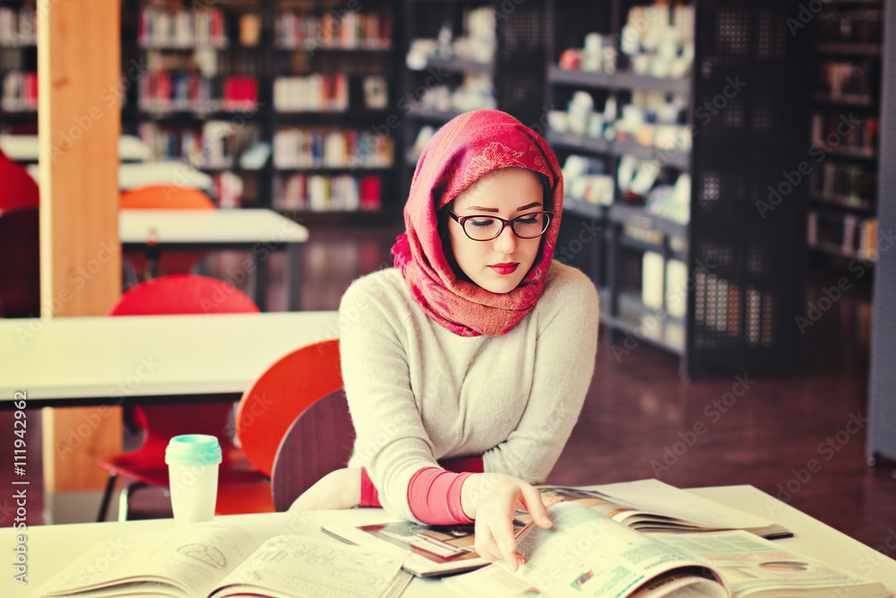 Muslim girl at the library with book Stock Photo | Adobe Stock