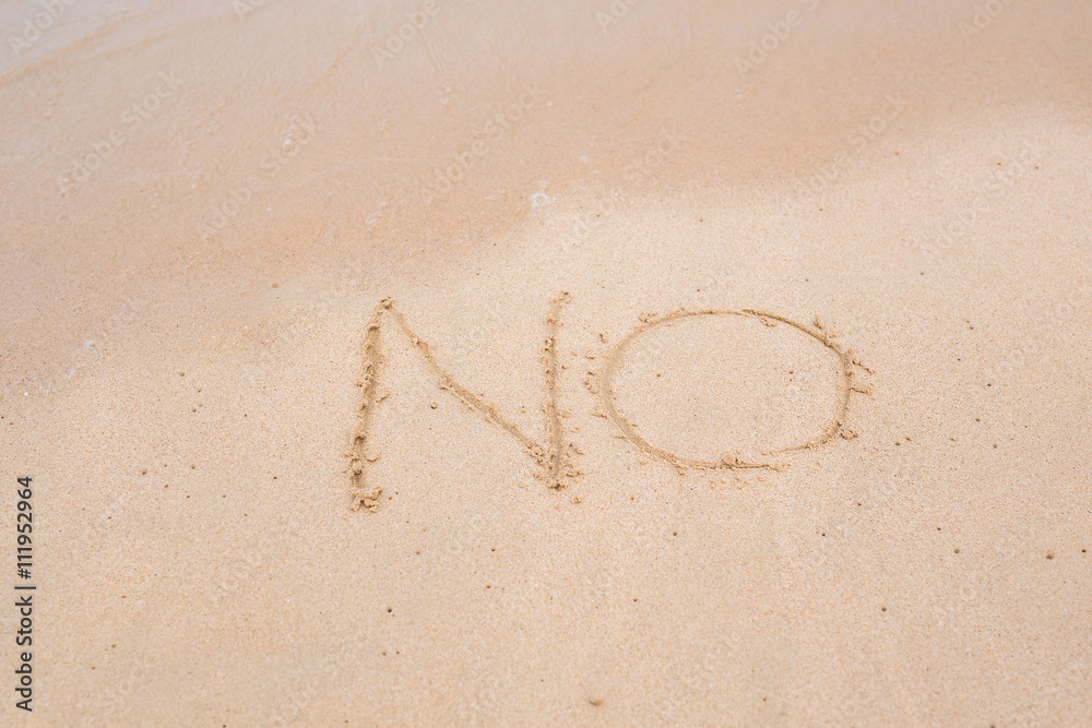 NO sign written in sand on beach texture sunny background. Closeup ...