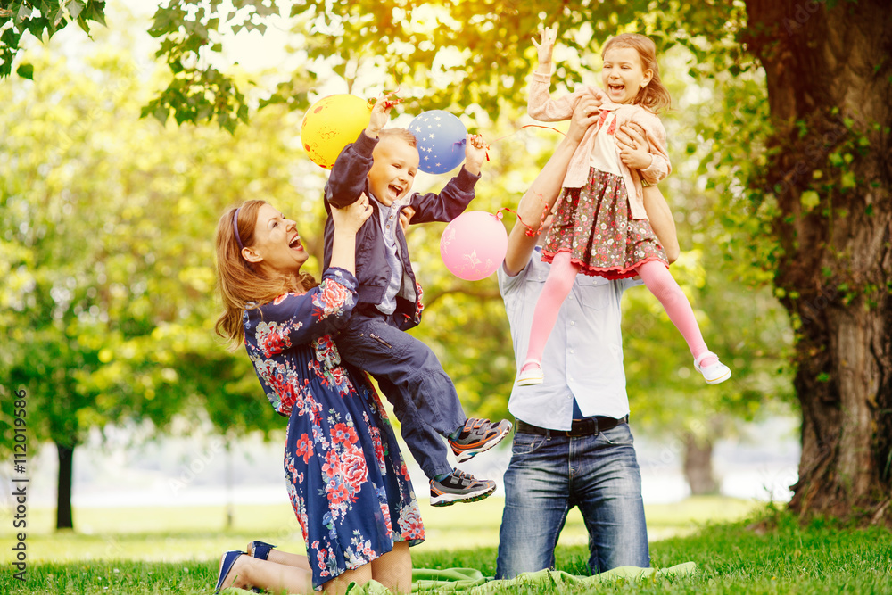 Young happy family having fun in the park Stock Photo | Adobe Stock