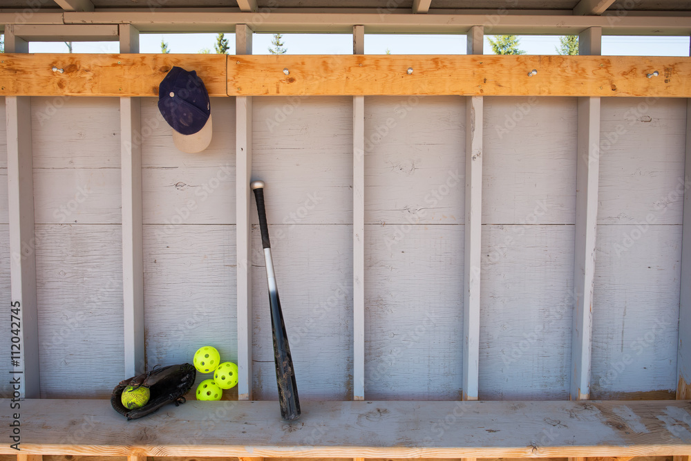 Baseball bat, hat, glove and ball leaning against a wall in a baseball ...