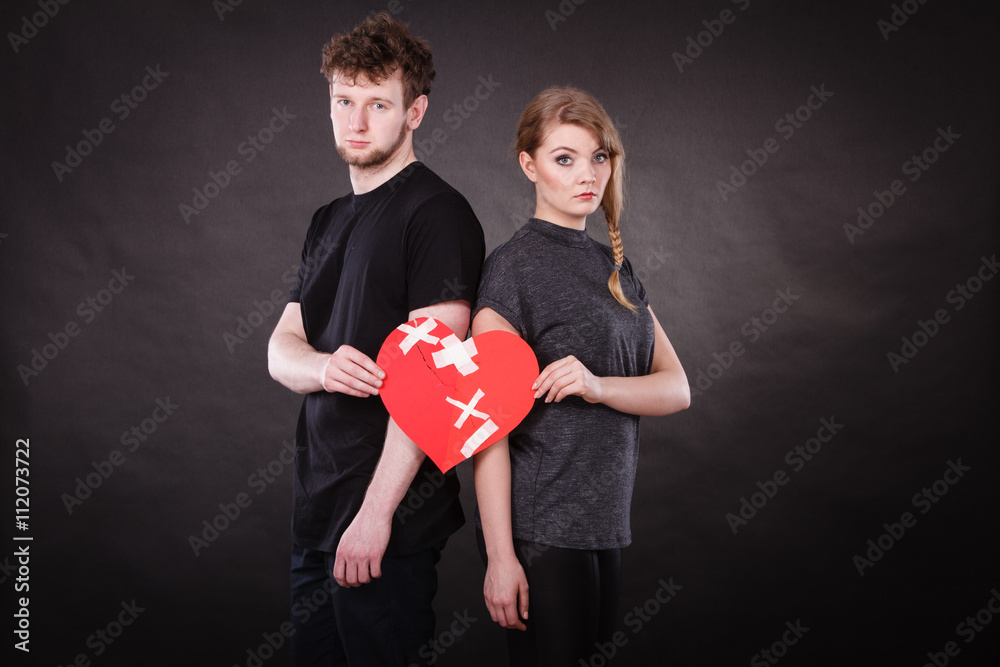 Sad couple holds broken heart. Stock Photo | Adobe Stock