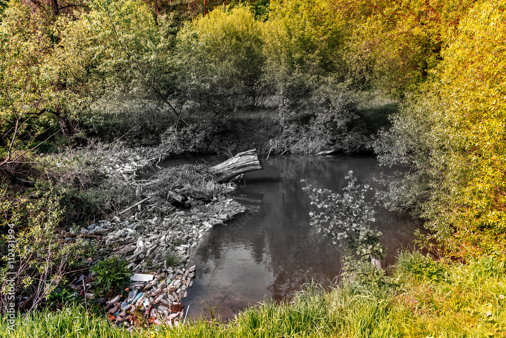 ecology concept. small river, water pollution, empty plastic bottles ...