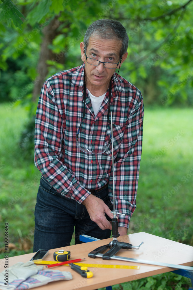 Foto Stock Senior Man screwing on a bench a tight seal | Adobe Stock