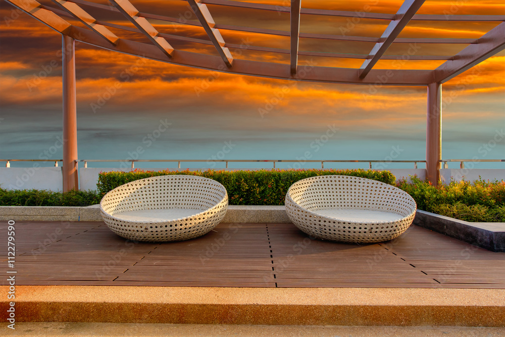 Relax corner on condominium rooftop garden with chairs on red sky ...