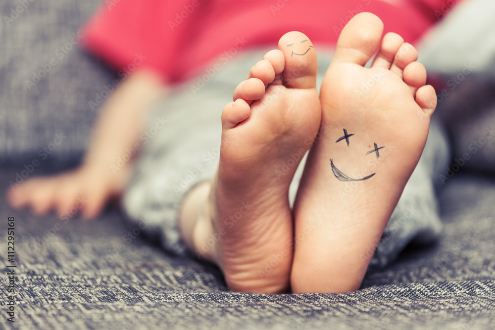 Kids feet with smiley faces drawings Stock Photo | Adobe Stock