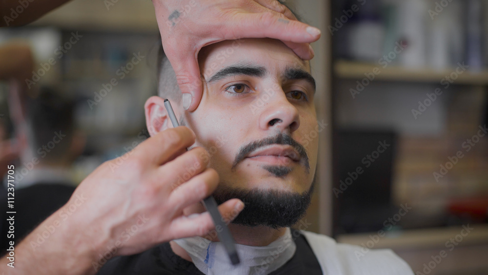 Hipster hairstyles in the salon. Professional barber uses a straight ...