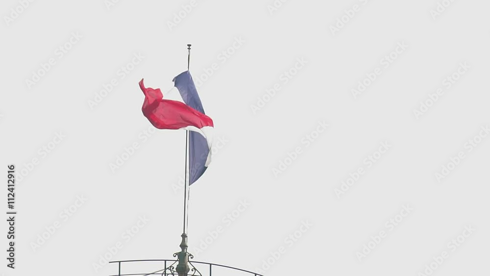 Beautiful French flag hanging on top of building, waving in wind, slow ...