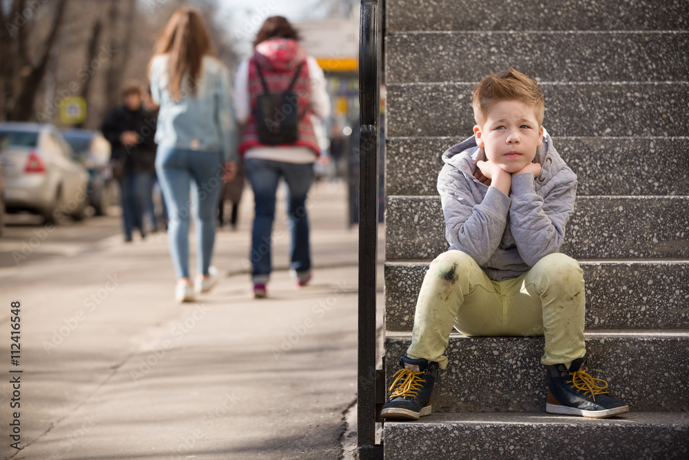 Child sitting on the stone steps. Portrait of handsome kid boy wearing ...