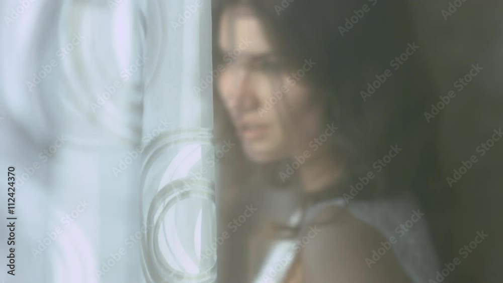 Gorgeous young woman posing while standing at the window in a hotel ...