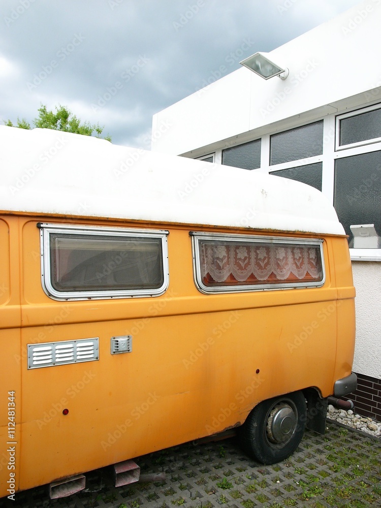 Foto de Altes Wohnmobil in mattem Orange mit weißem Hochdach der ...