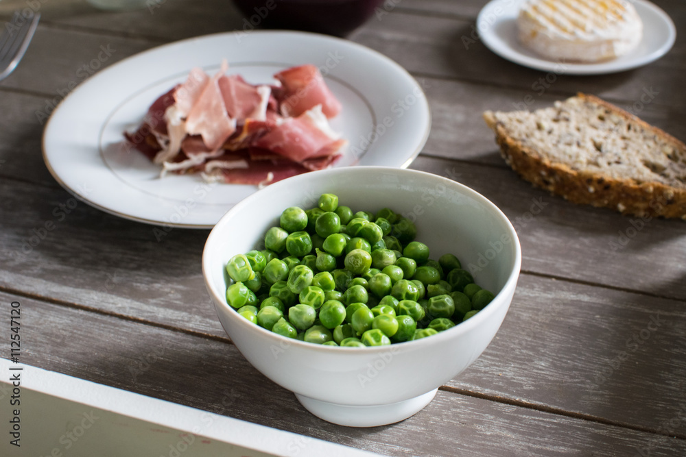 Foto de Plateau repas bio : gros plan sur un bol de petits pois, jambon ...