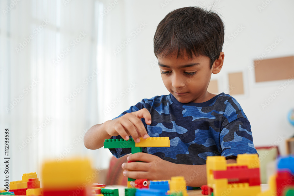 Asian kid building with plastic colorful bricks Stock Photo | Adobe Stock