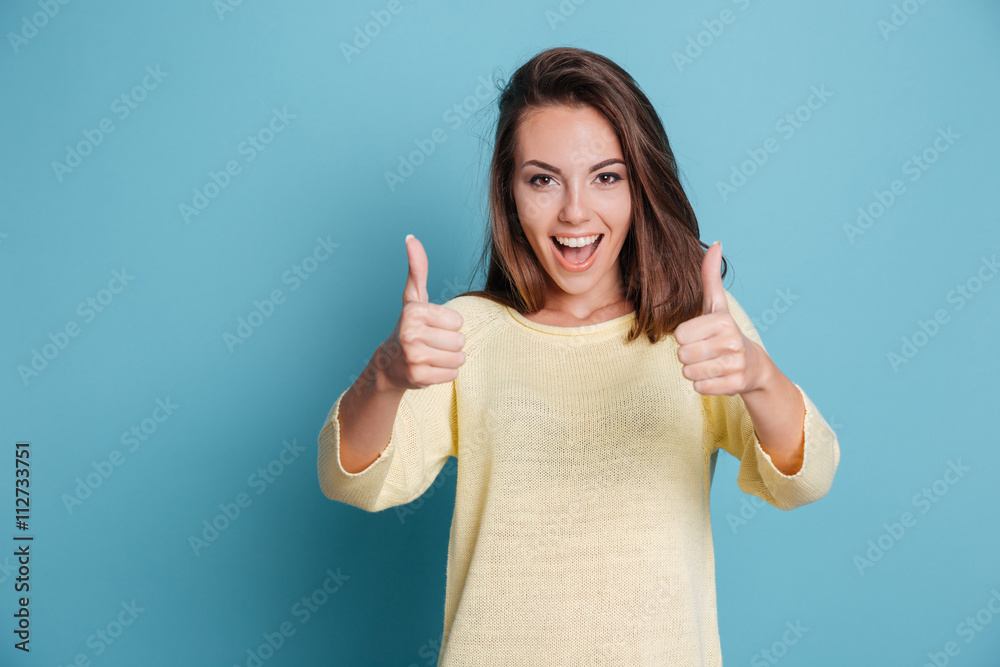 Smiling pretty young woman showing thumbs up Stock Photo | Adobe Stock