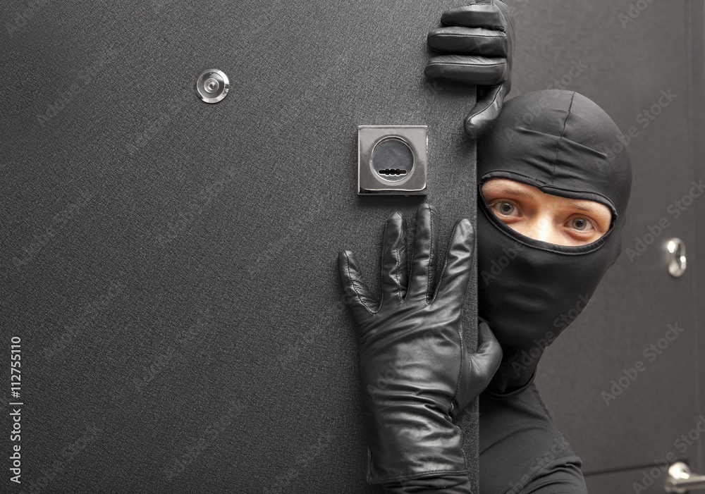 Ninja. Robber hiding behind a door Stock-Foto | Adobe Stock
