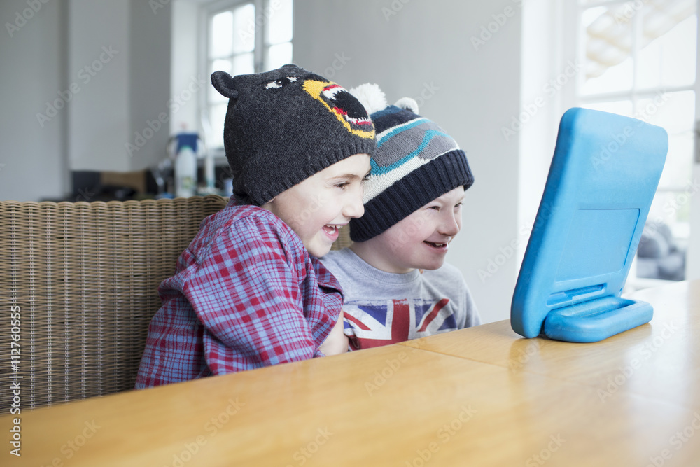 Boy With Downs Syndrome And Brother Using Computer At Home Stock Photo ...