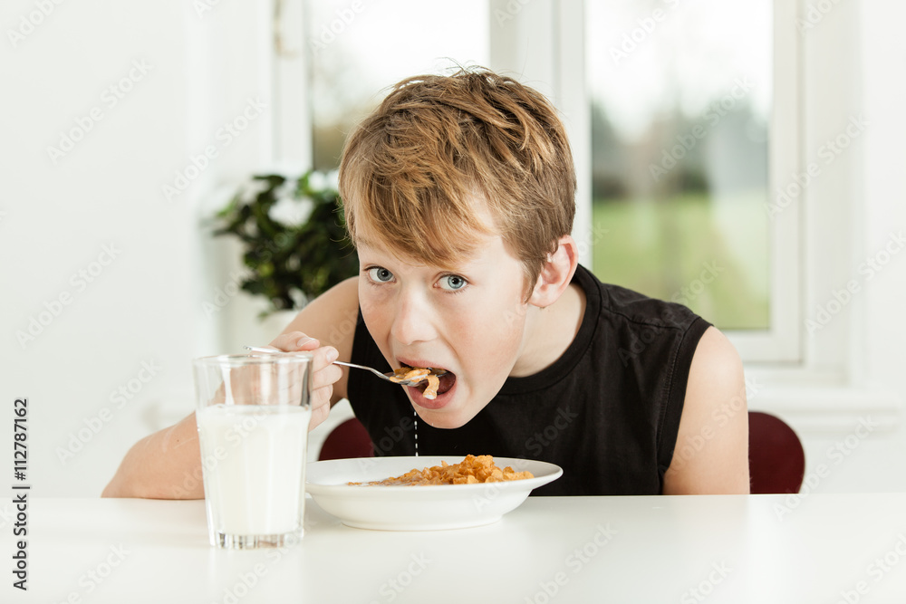 Teenage Boy Eating Breakfast Cereal in Morning Stock Photo | Adobe Stock