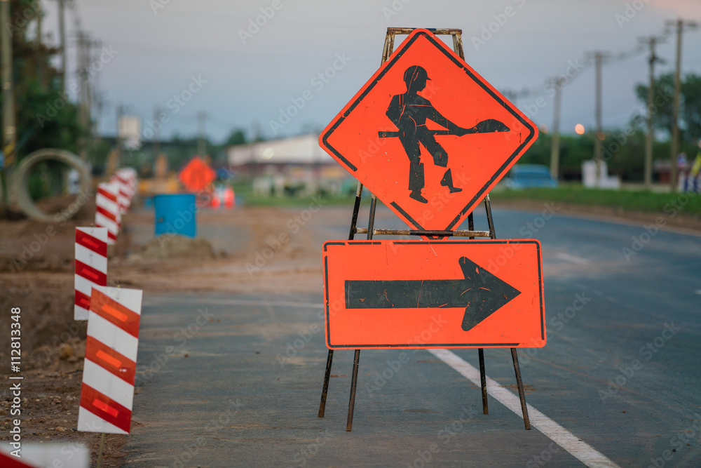 Construction sign on country road with red and white warning sign on ...