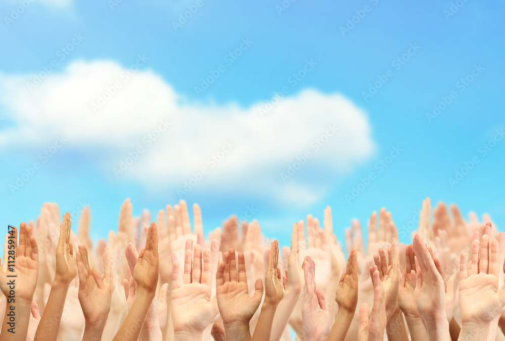Crowd raising hands on blue sky background Stock Photo | Adobe Stock