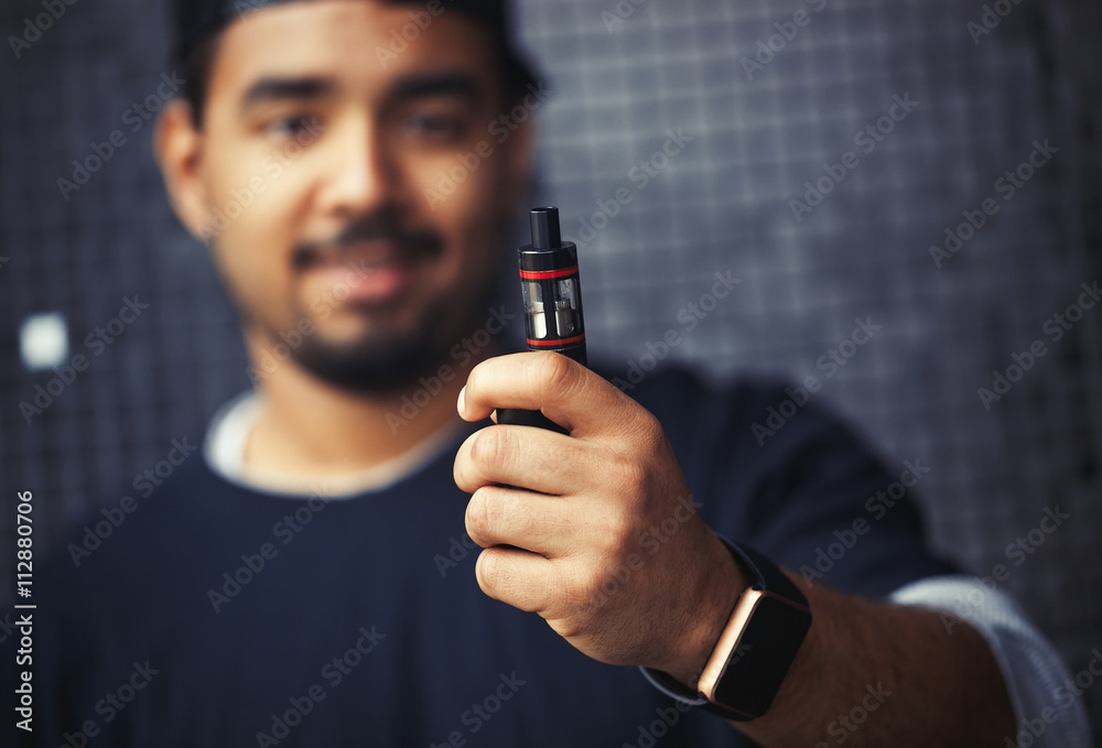 Young black man holding a vaping device in hand. Diverse and inclusive ...