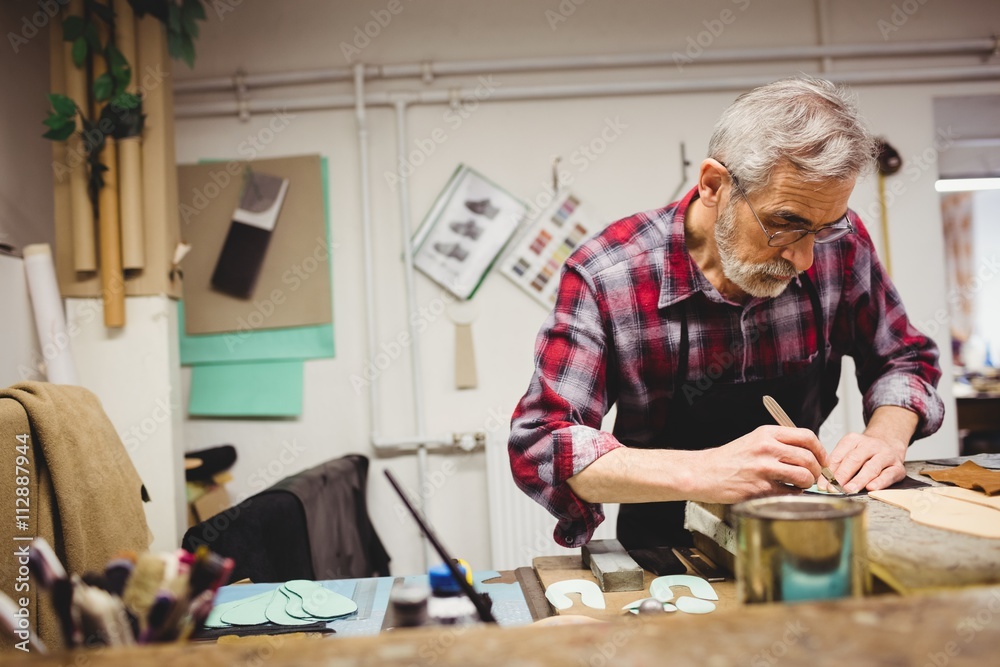 Concentrated cobbler drawing shoes Stock Photo | Adobe Stock