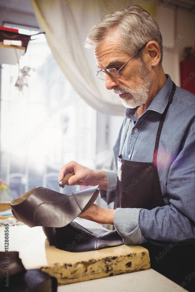 Profile view of cobbler making a shoe Stock Photo | Adobe Stock
