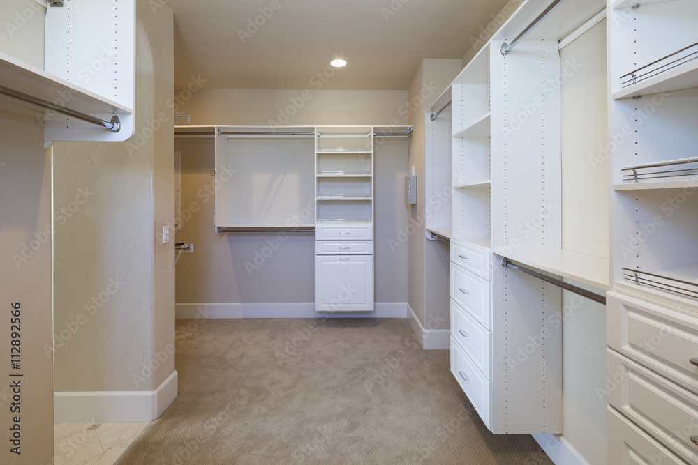 Large white walk-in closet with shelves. Stock Photo | Adobe Stock